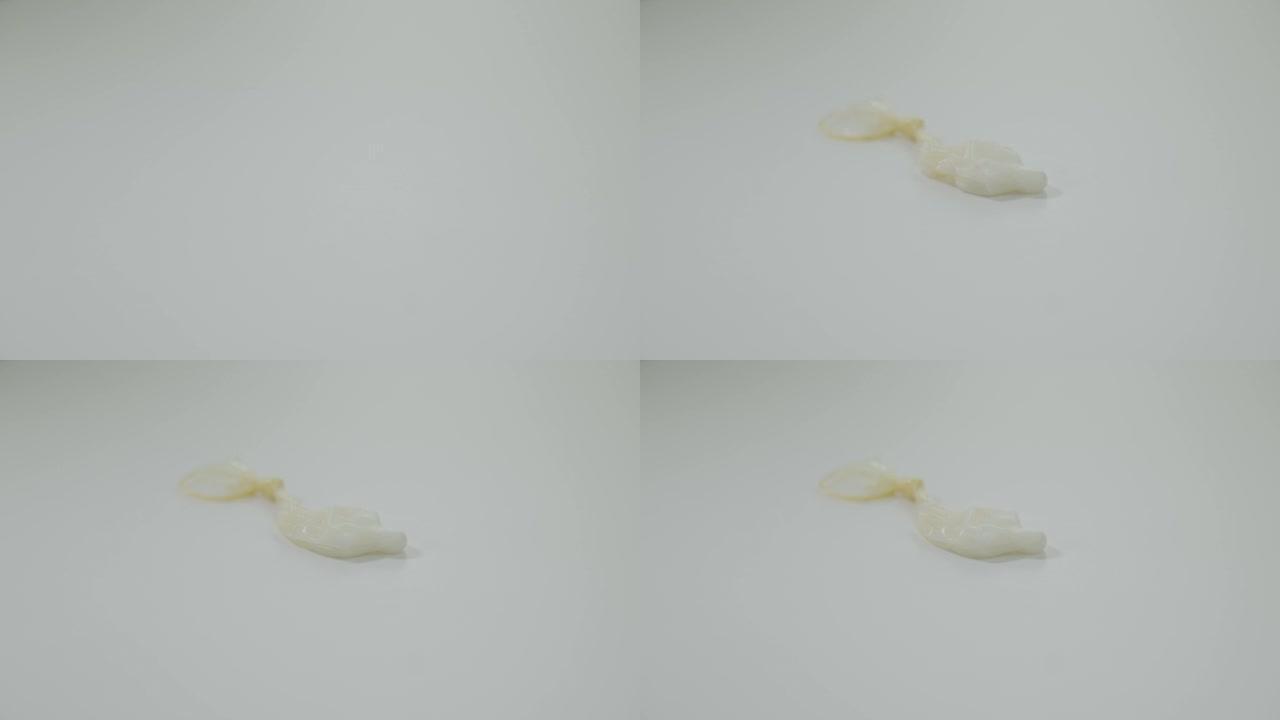 特写用过的避孕套落在白色背景的白色桌子上。用精液特写捆绑避孕药。视频素材下载编号19043207光厂vj师网