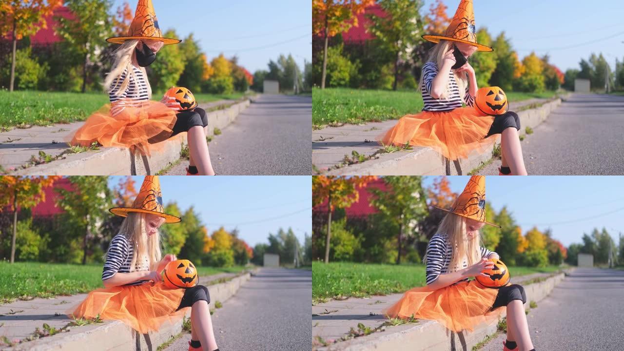 4k。万圣节儿童面具。穿着女巫服装和南瓜桶的金发女孩。孩子戴上黑色口罩在户外吃糖果。防止新型冠状病毒 视频素材下载